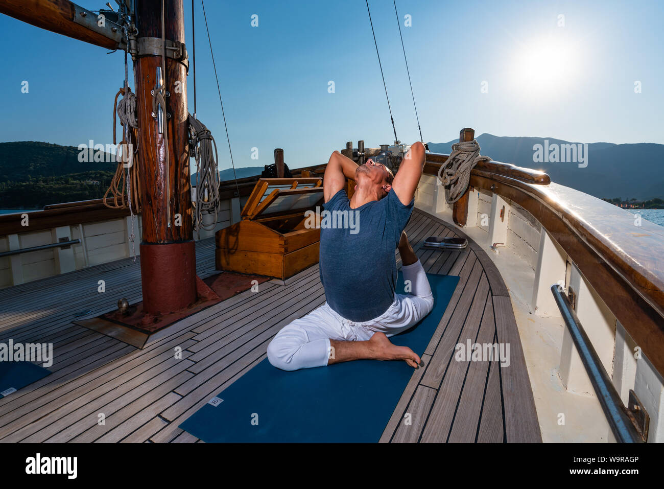Man practicing Yoga on a sailing yacht at sea Stock Photo - Alamy