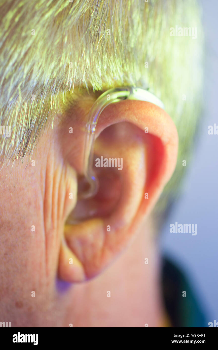 Caucasian white old aged man wearing modern digital hearing aid in ear ...