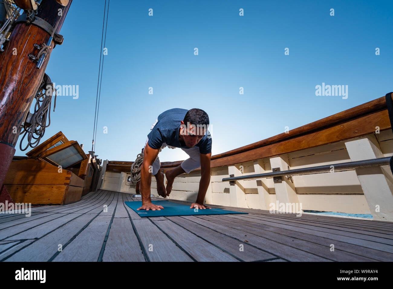 Man practicing Yoga on a sailing yacht at sea Stock Photo - Alamy