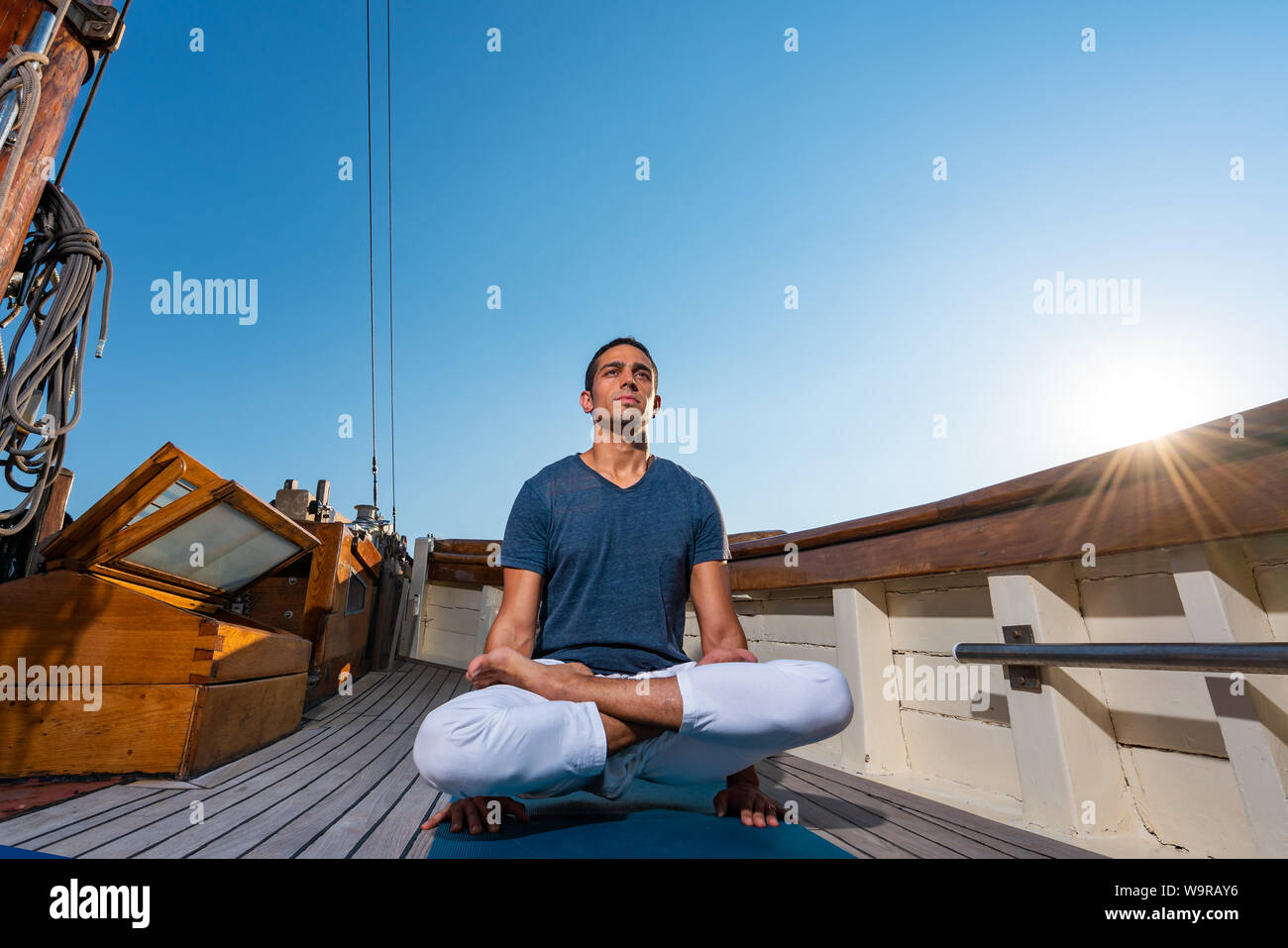 Man practicing Yoga on a sailing yacht at sea Stock Photo - Alamy