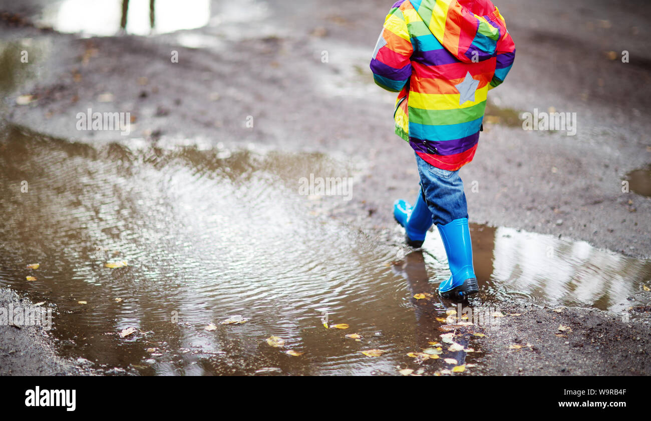 Child walking in wellies in puddle on rainy weather Stock Photo - Alamy