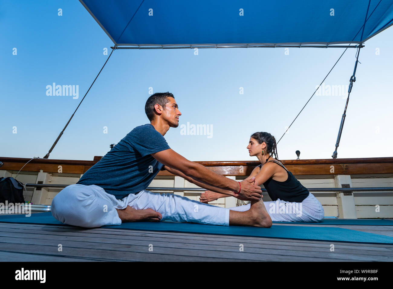 Couple practicing Yoga on a sailing yacht at sea Stock Photo - Alamy