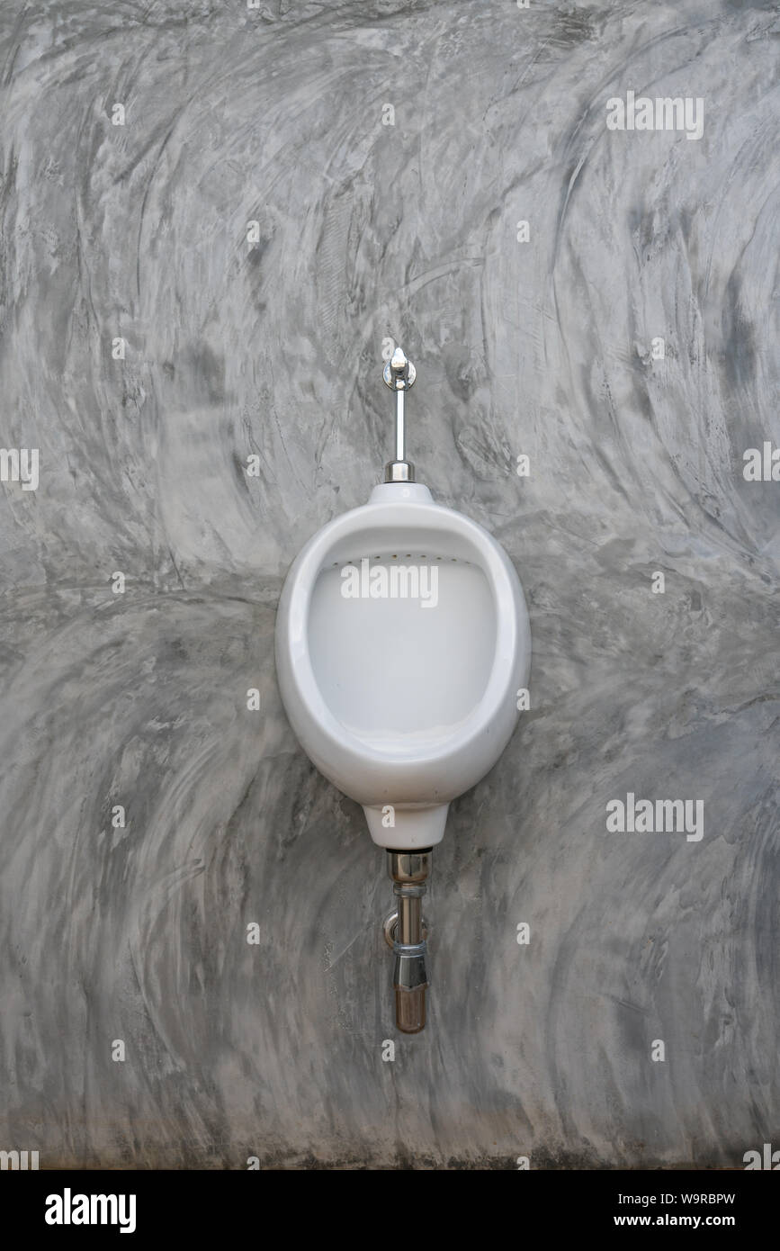 white urinal On The Concrete Wall Stock Photo - Alamy