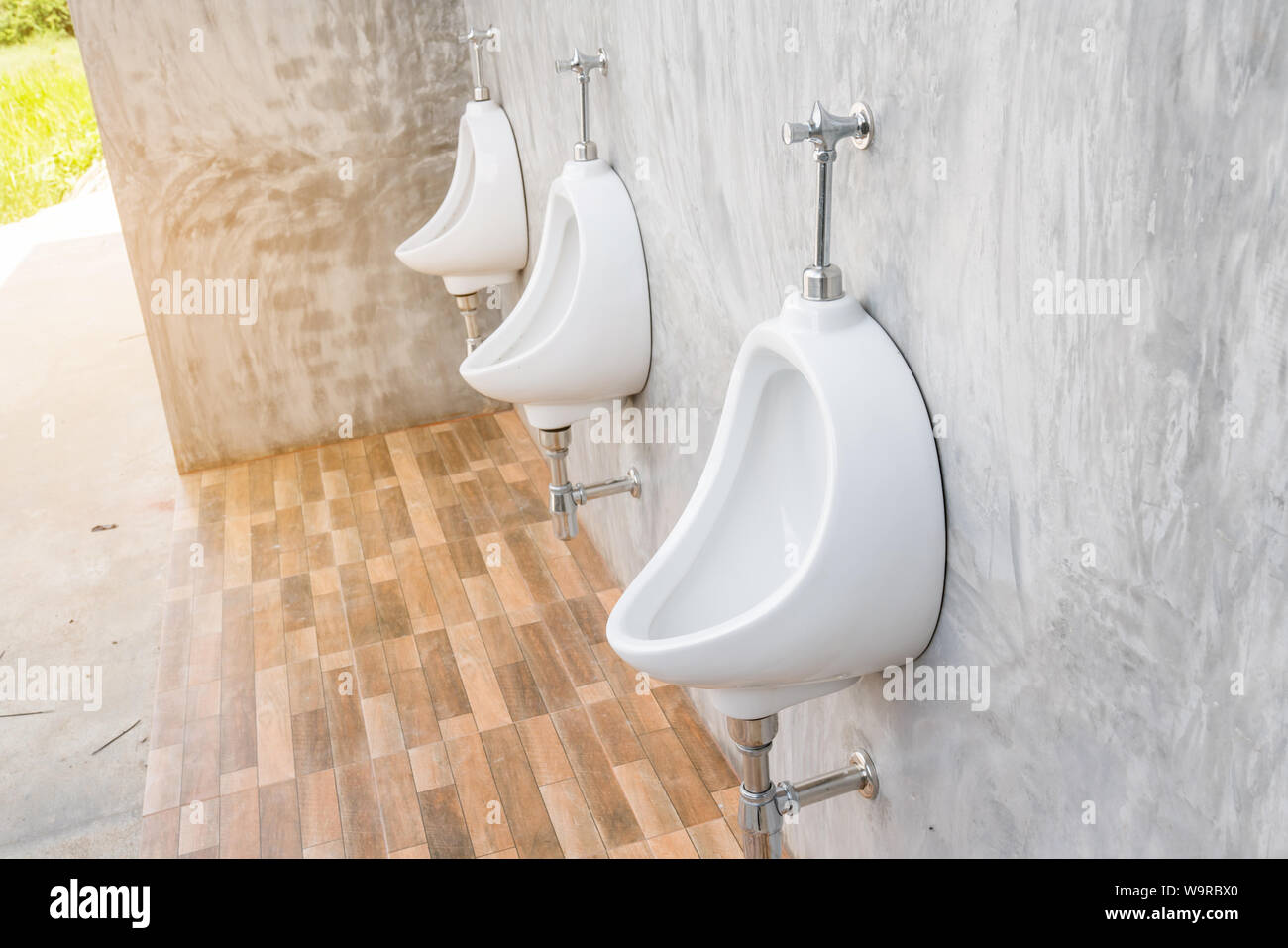 white urinal On The Concrete Wall Stock Photo - Alamy