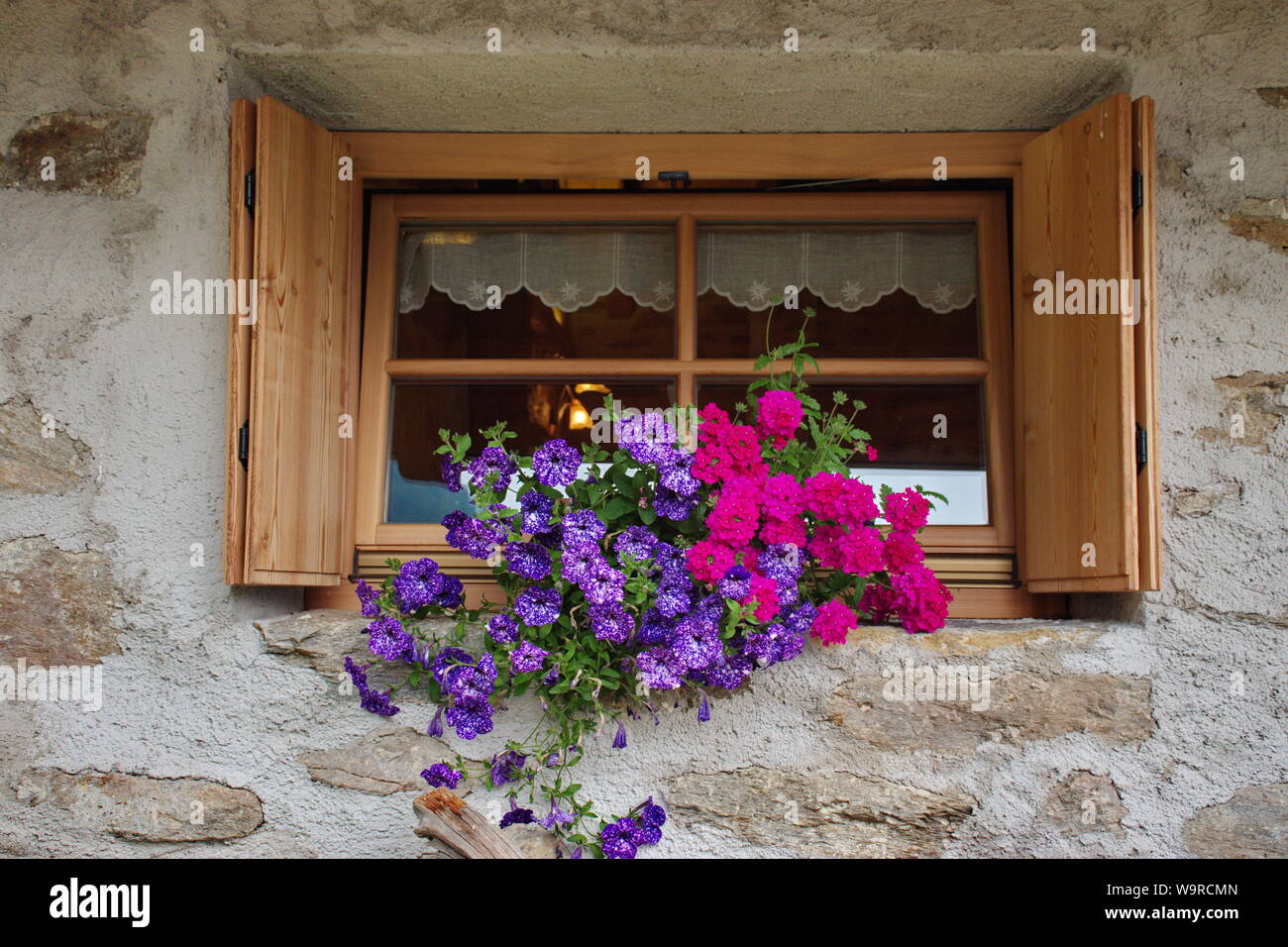 Window of the stone house decorated with flowers Stock Photo - Alamy
