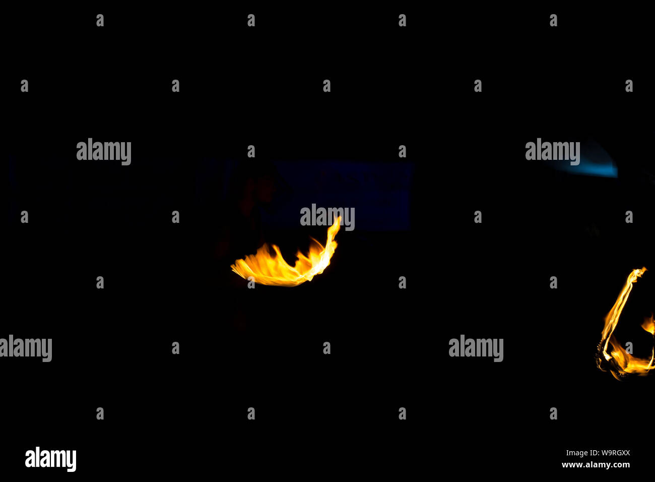 Motion blurred night shot showing a fire eater juggler's torches ...