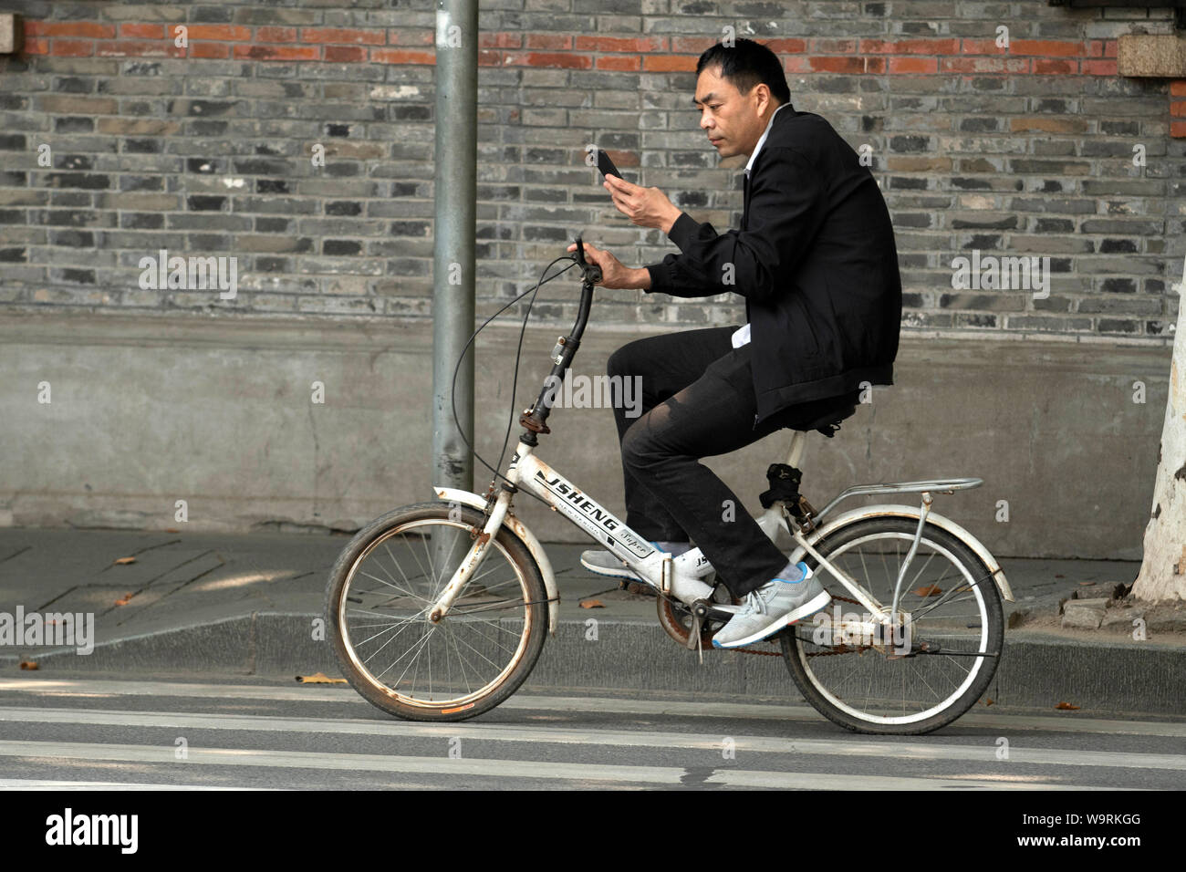 Asia, China, Peoples Republic, Shanghai , man on bike with cell phone ...