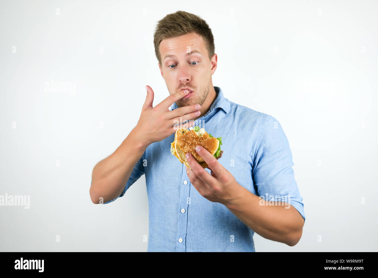 young handsome man enjoying cheeseburger from fast food restaurant ...