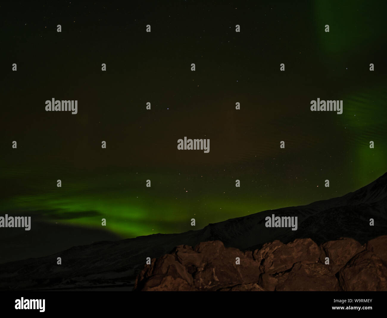 Rocks and mountains with green northern lights in Iceland. Photo from ...