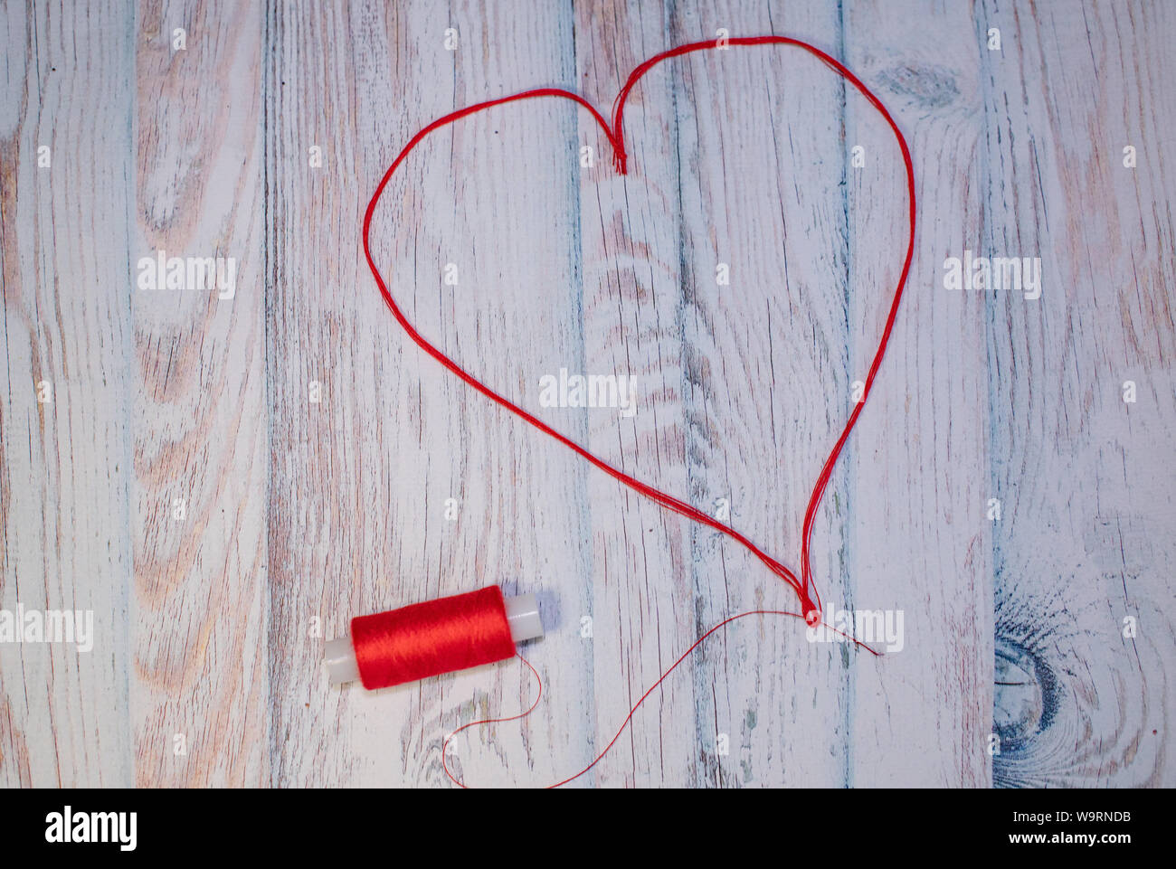 Hobbies and crafts concept, the heart of the factory threads on a blue ...