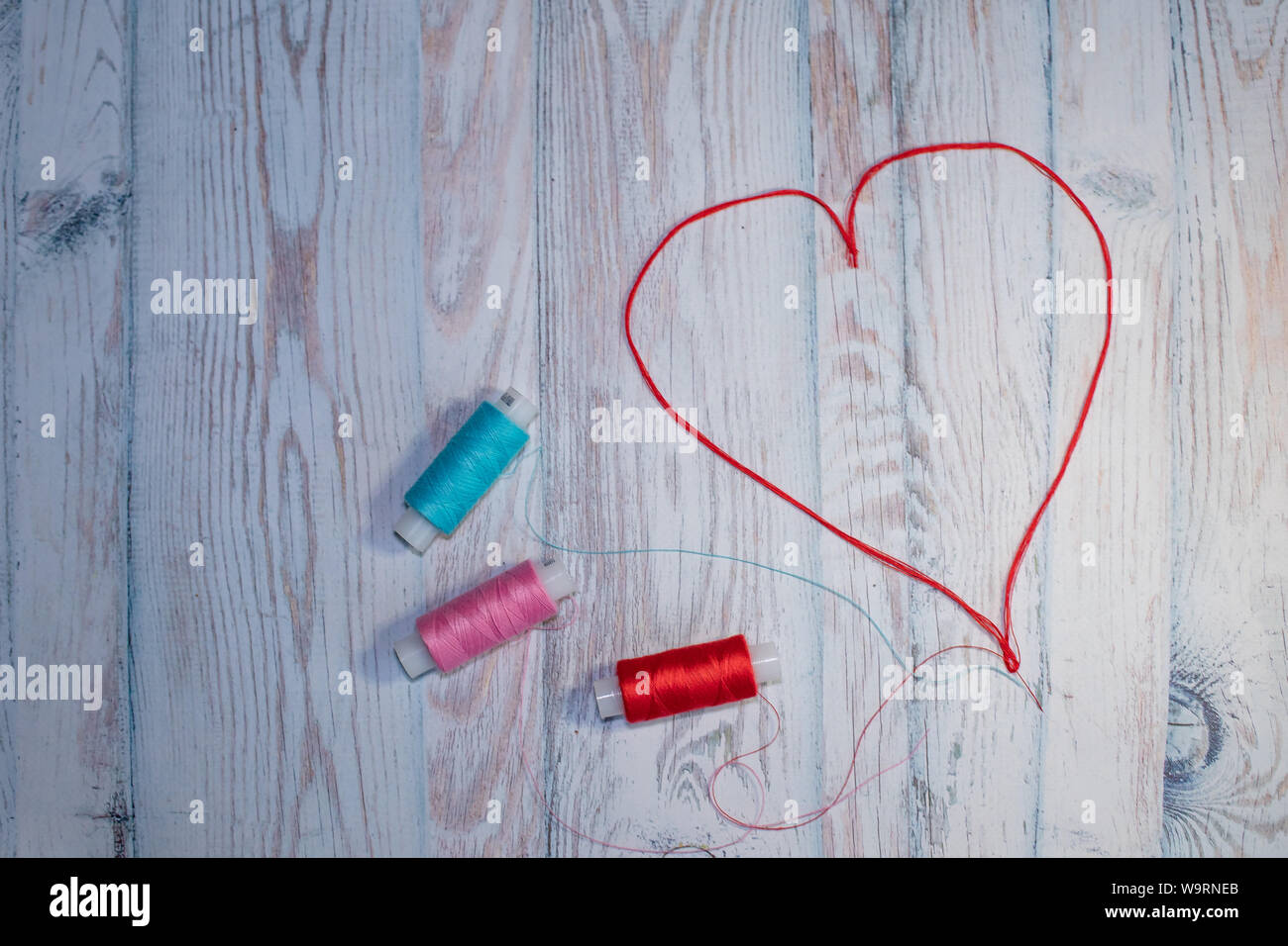 Hobbies and crafts concept, the heart of the factory threads on a blue ...