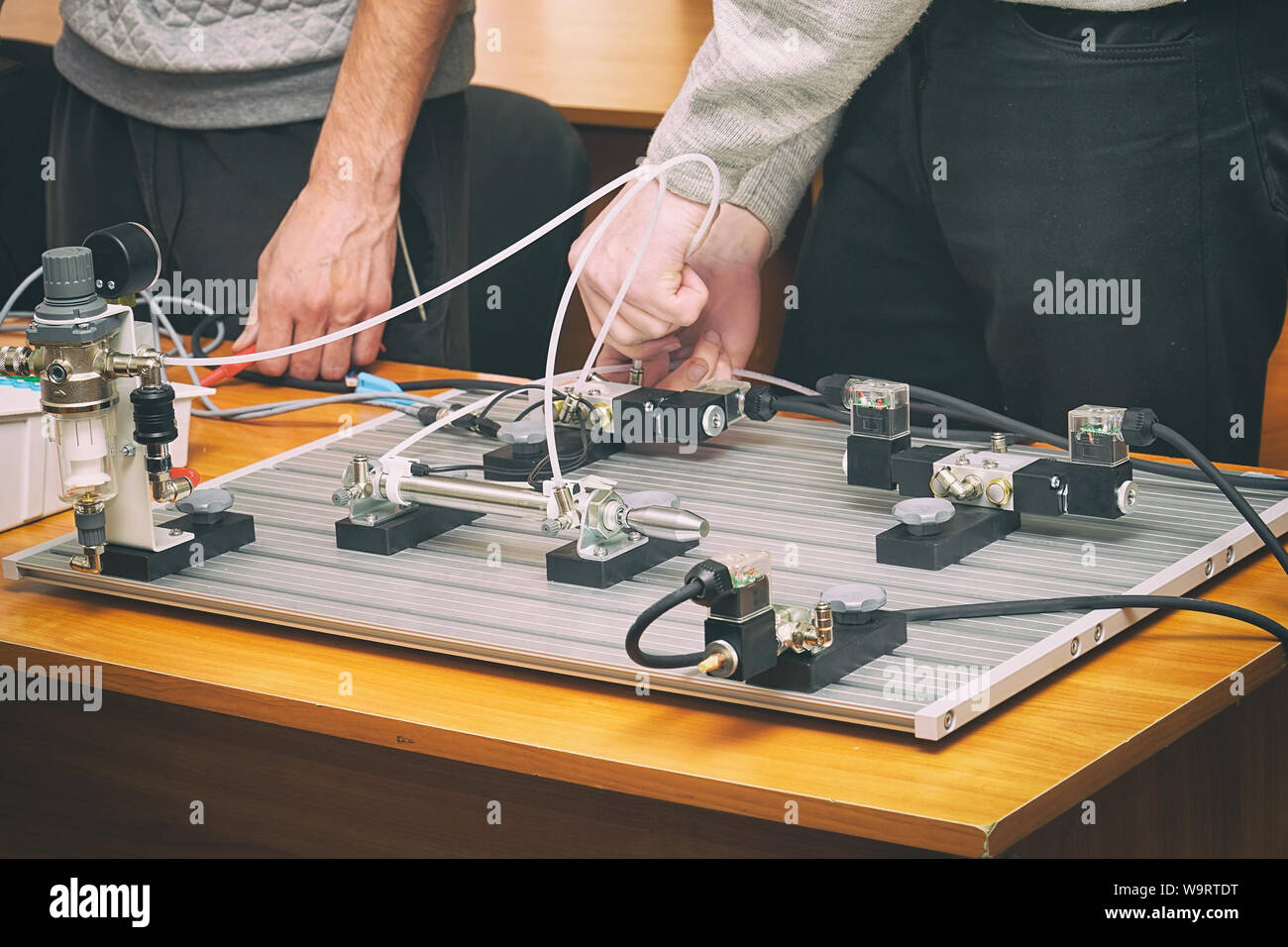 Engineers connect wires control panel with small test bench for ...