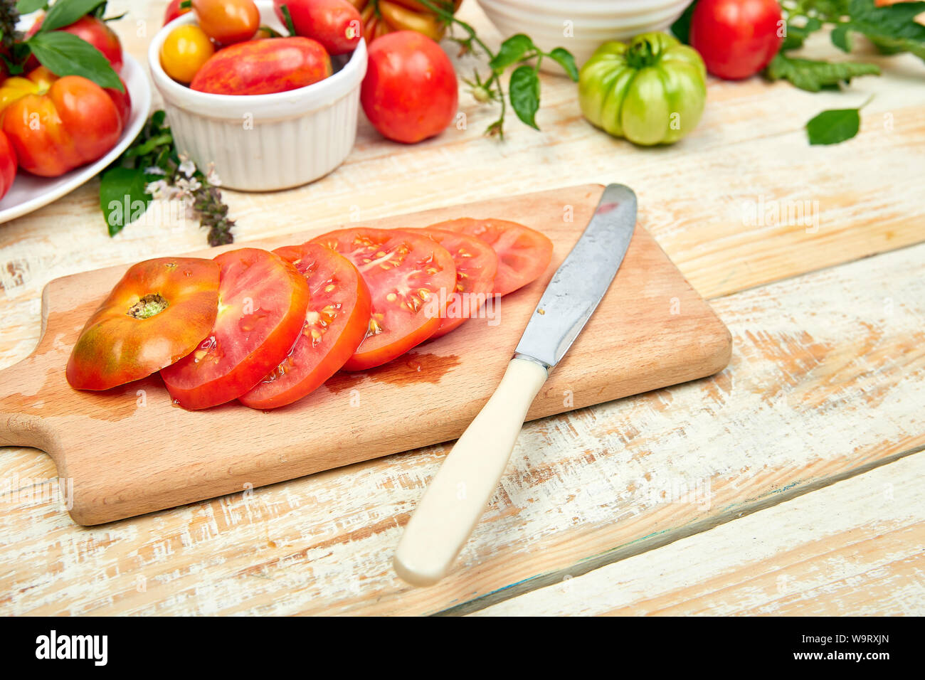 Chopped tomatoes and knife on cutting board. Mix of tomatoes background ...