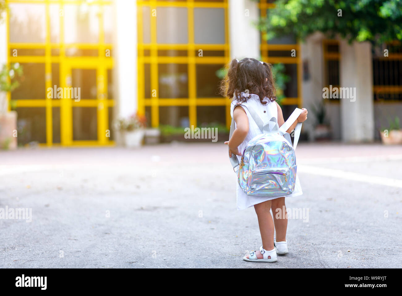 Back to school. Cute child girl with holographic backpack running and ...