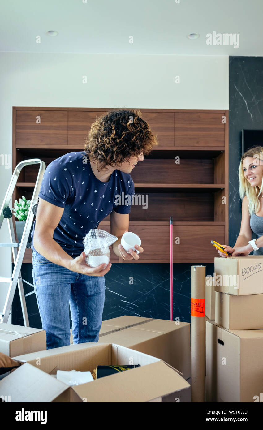 Couple unpacking moving boxes in their new house Stock Photo - Alamy