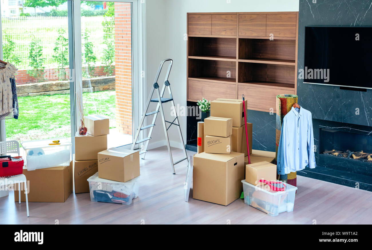 Large living room with stack of moving boxes Stock Photo - Alamy