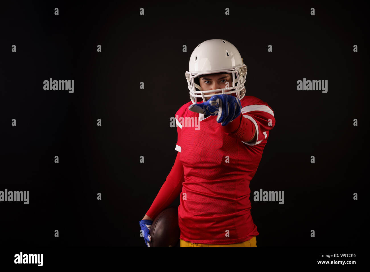 Photo of american female football player in helmet with arm ...
