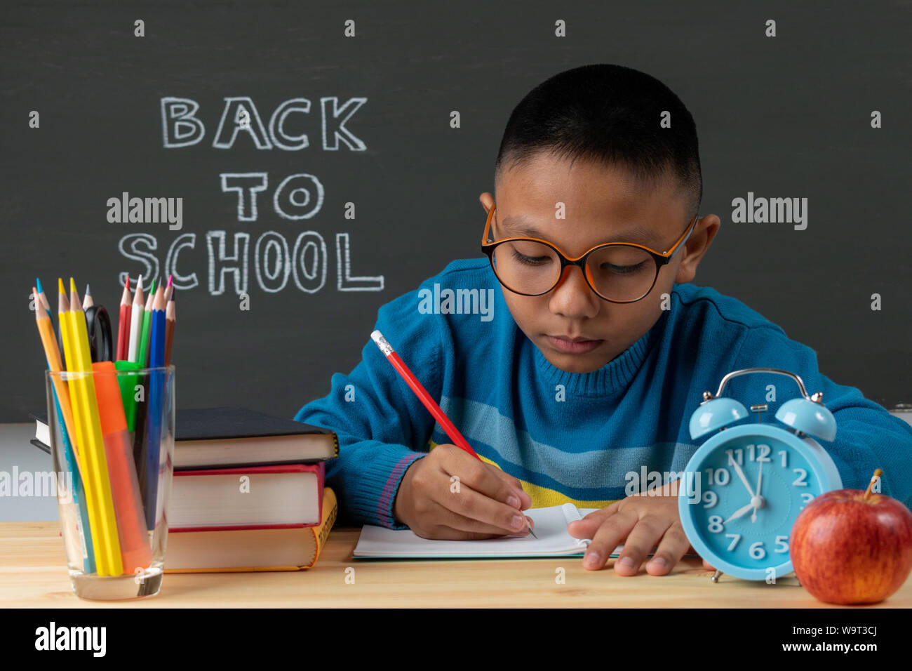 A boy writing a book in the classroom. Back to school concept Stock ...