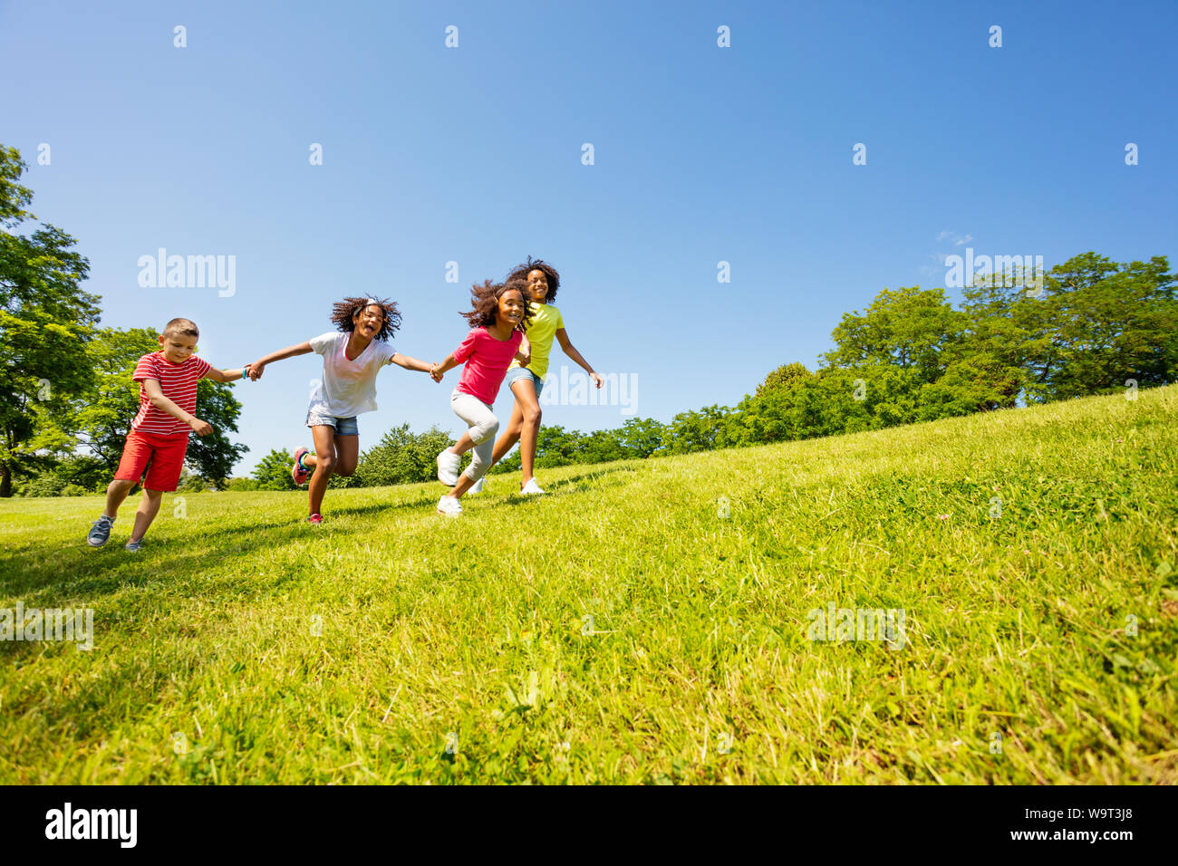 Crazy cute happy kids run in park holding hands Stock Photo - Alamy
