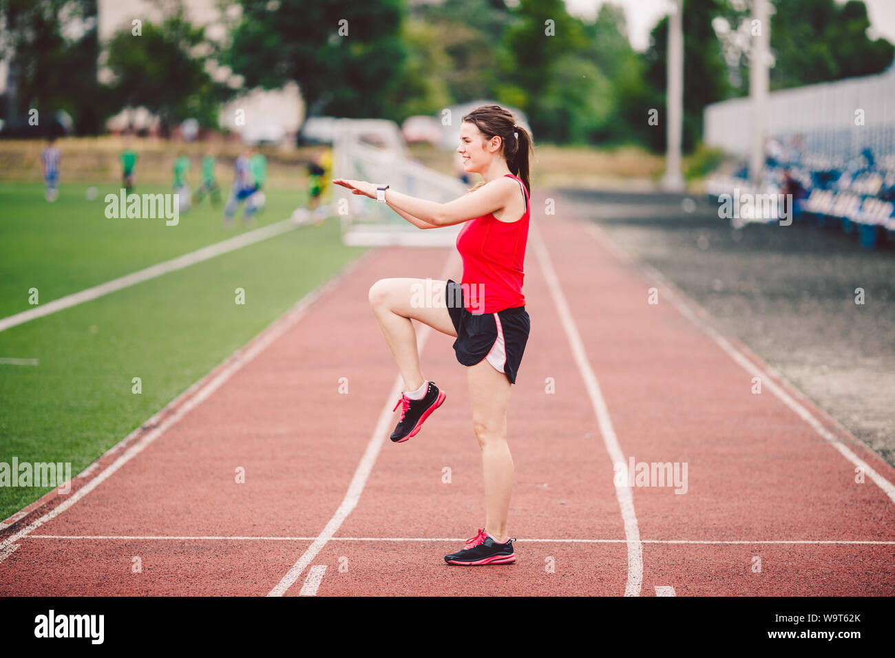 Female athlete preparing legs for cardio workout. Fitness runner doing ...