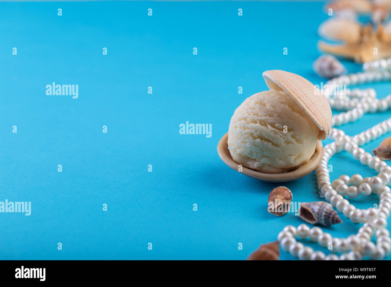 vanilla ice-cream like pearl in sea shell on blue background deep sea ...