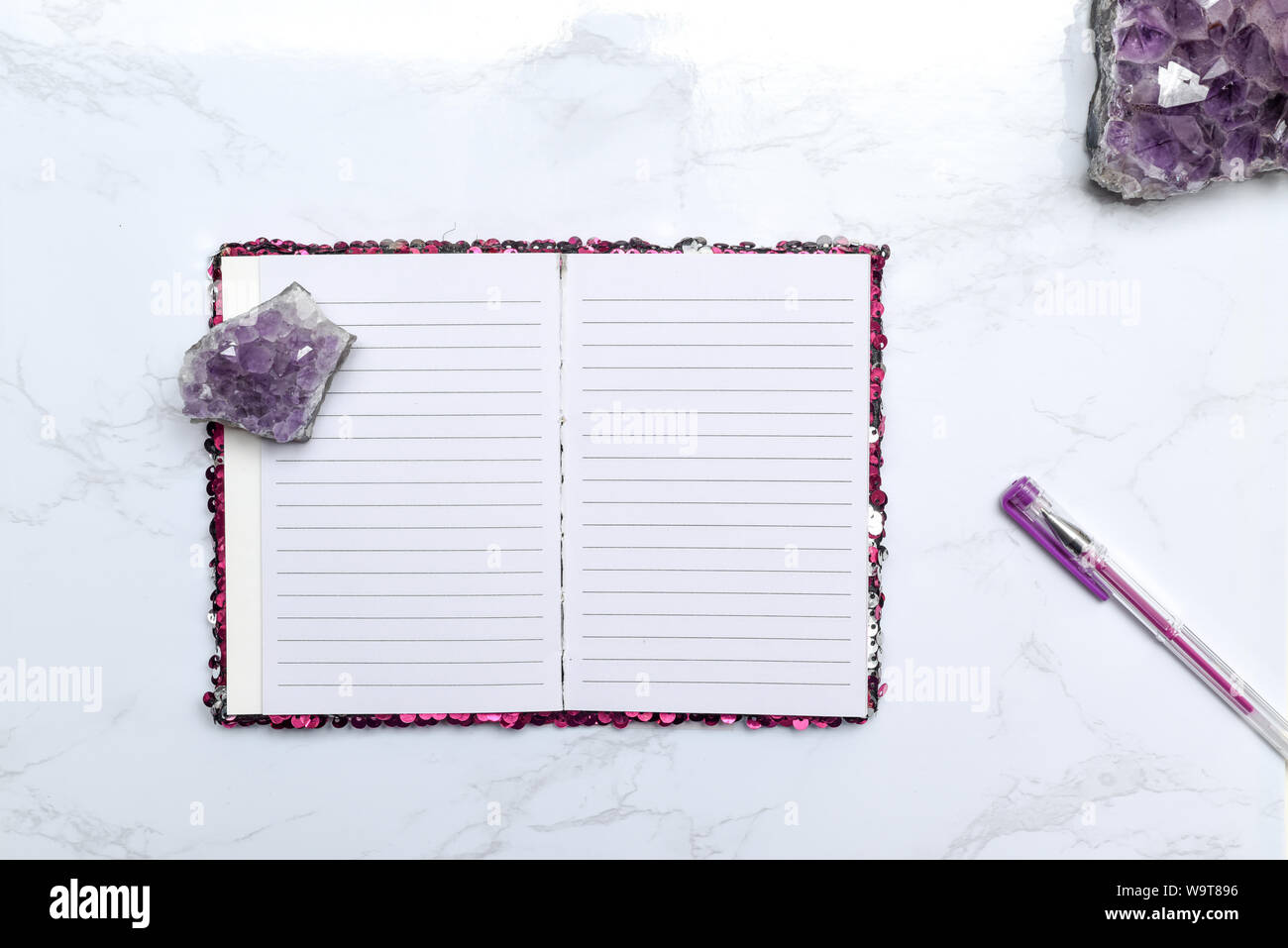 Purple themed stationary set with notebook and pen on a modern marble ...
