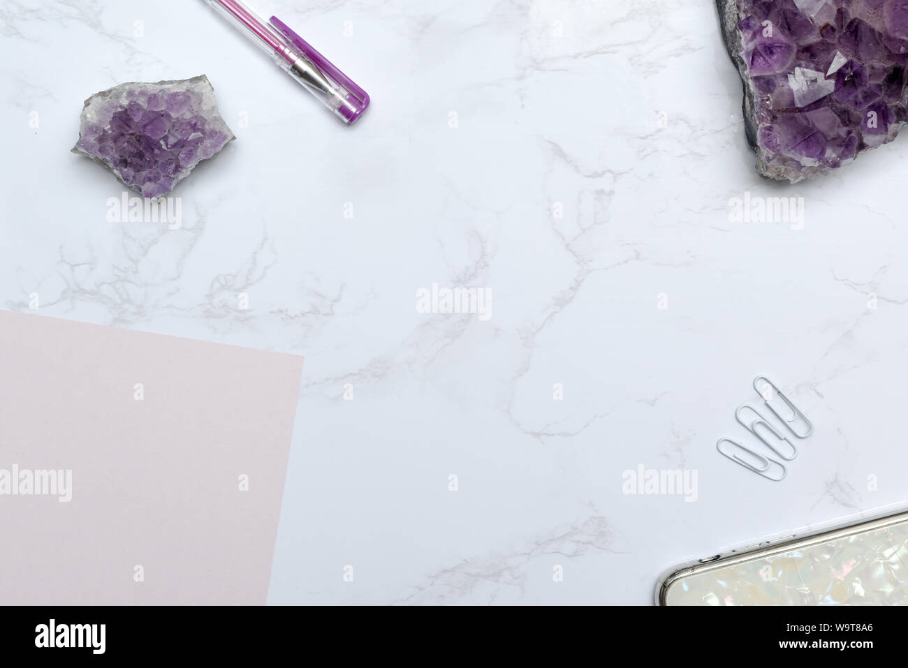 Purple themed stationary set with notebook and pen on a modern marble ...