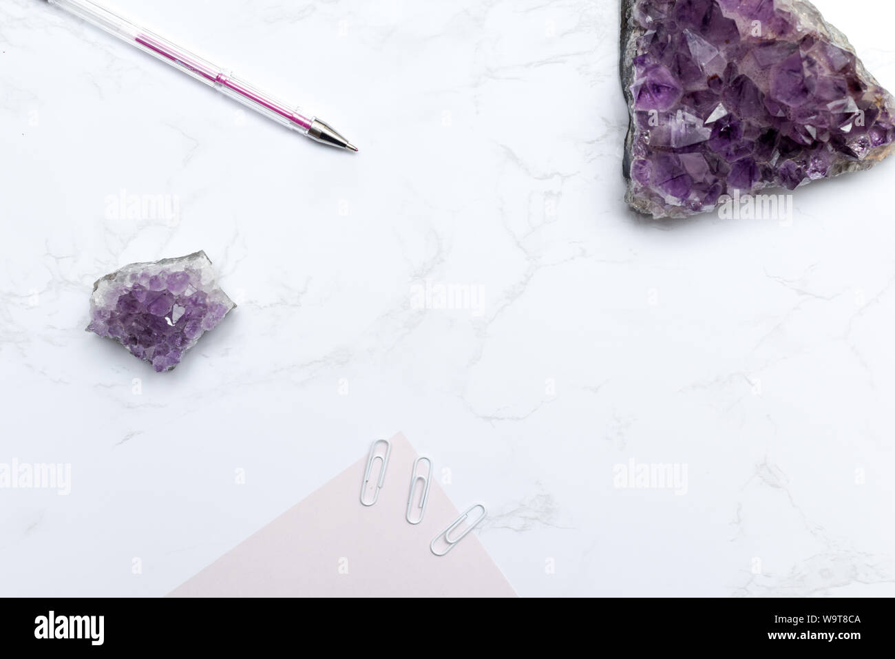 Purple themed stationary set with notebook and pen on a modern marble ...