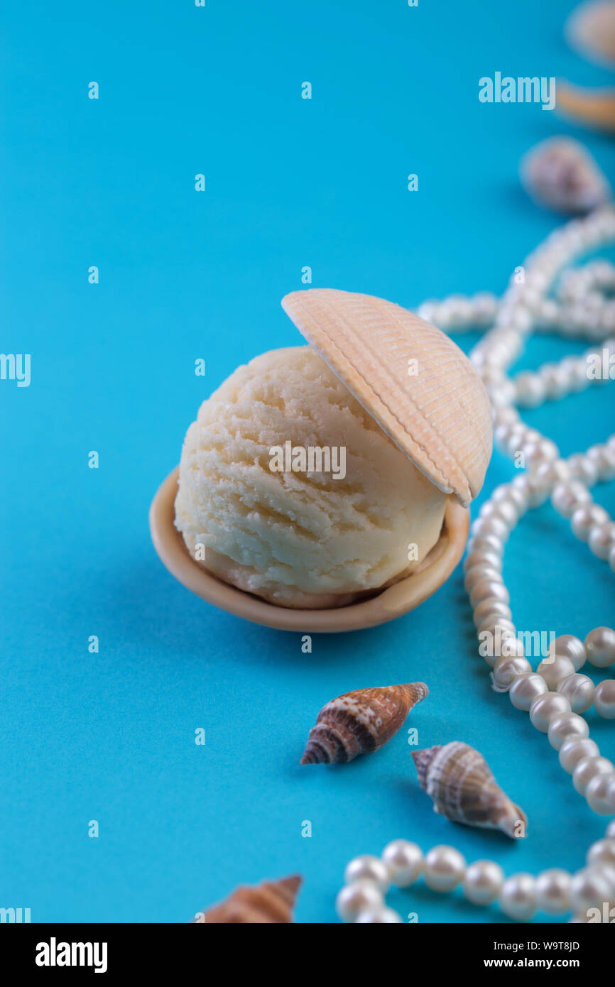 vanilla ice-cream like pearl in sea shell on blue background deep sea ...