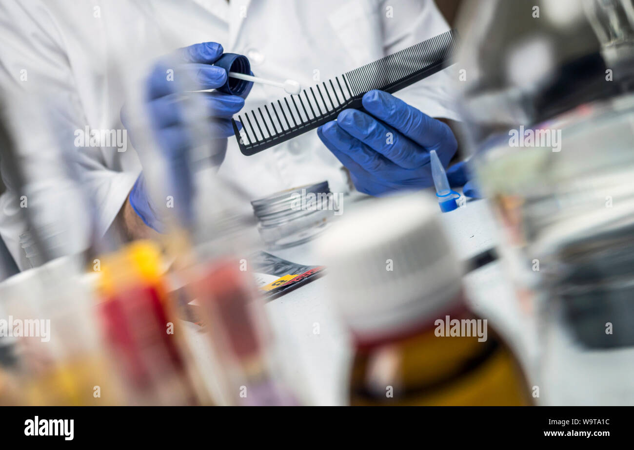 Scientist Police hold murder victim comb to find dna in crime lab ...