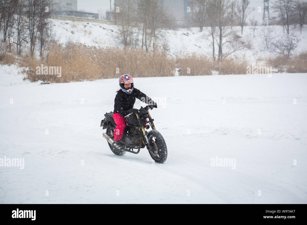 A girl rides a motorcycle on a frozen lake Stock Photo - Alamy