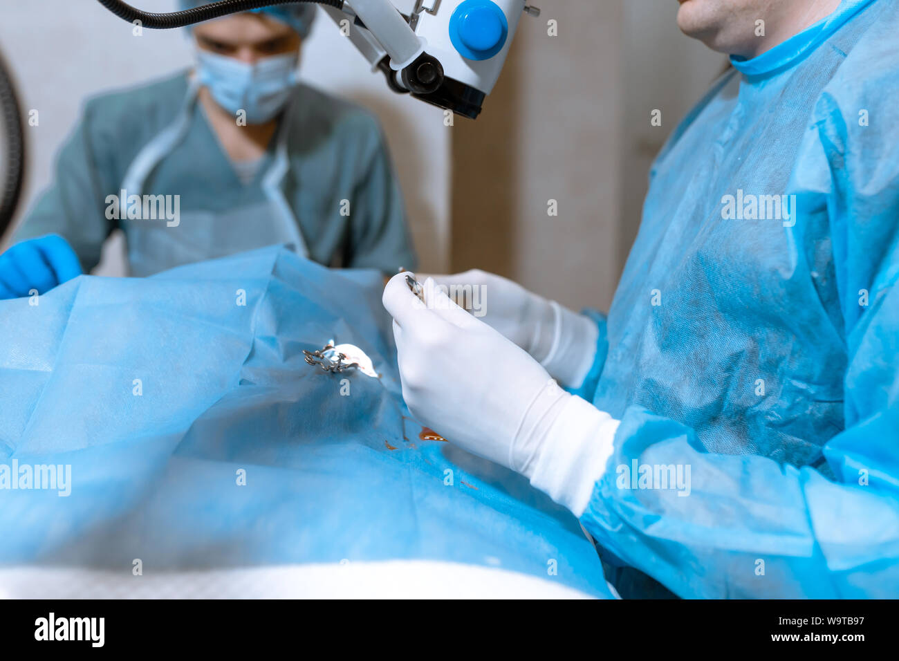 A professional ophthalmologist performs eye surgery with a microscope ...
