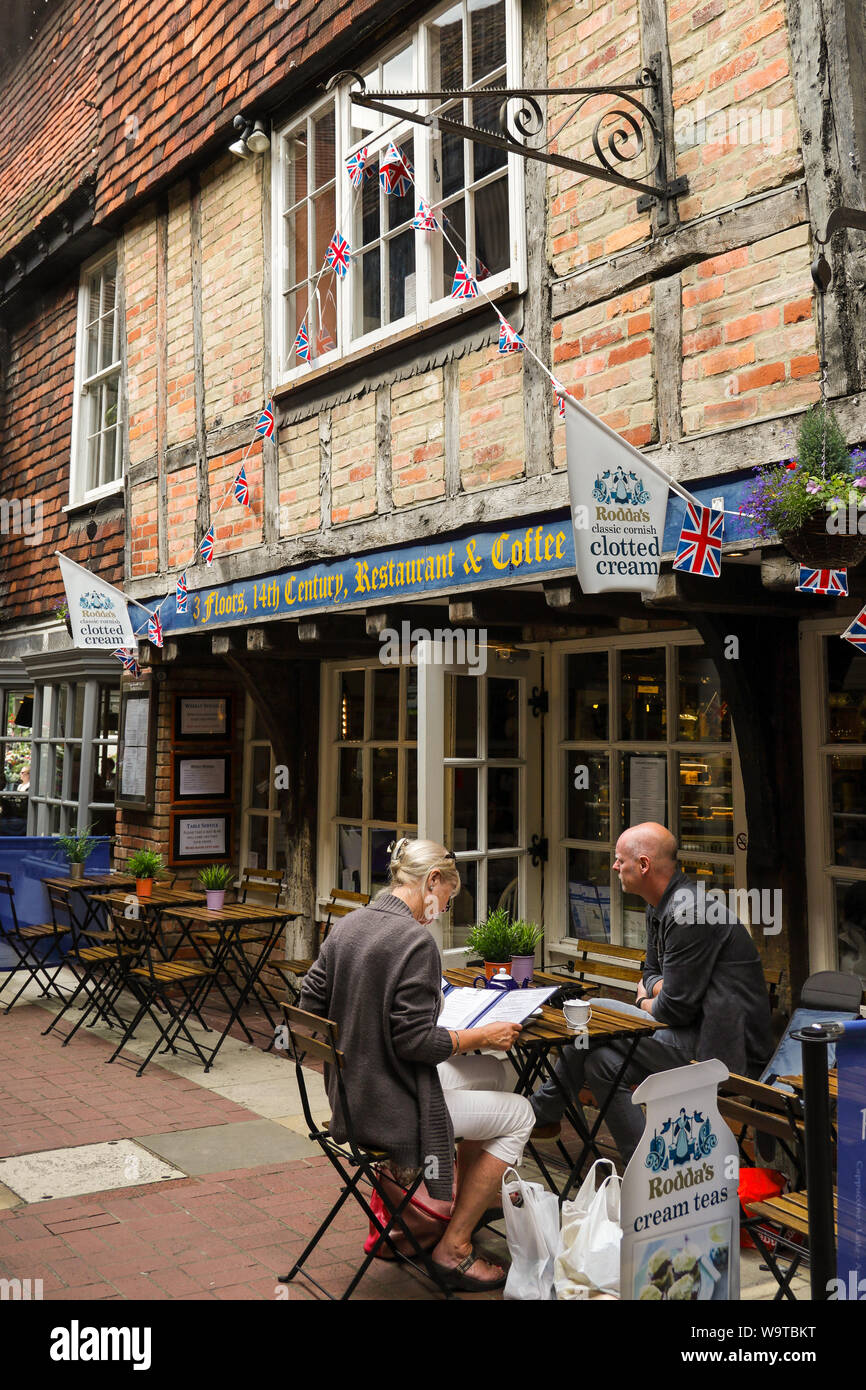 A couple sitting outside a traditional 14th century British Café ...