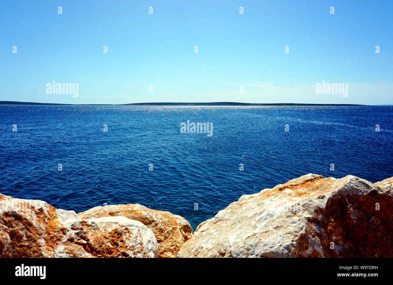 Seascape view with big rocks in front of blue sea surface on which the ...