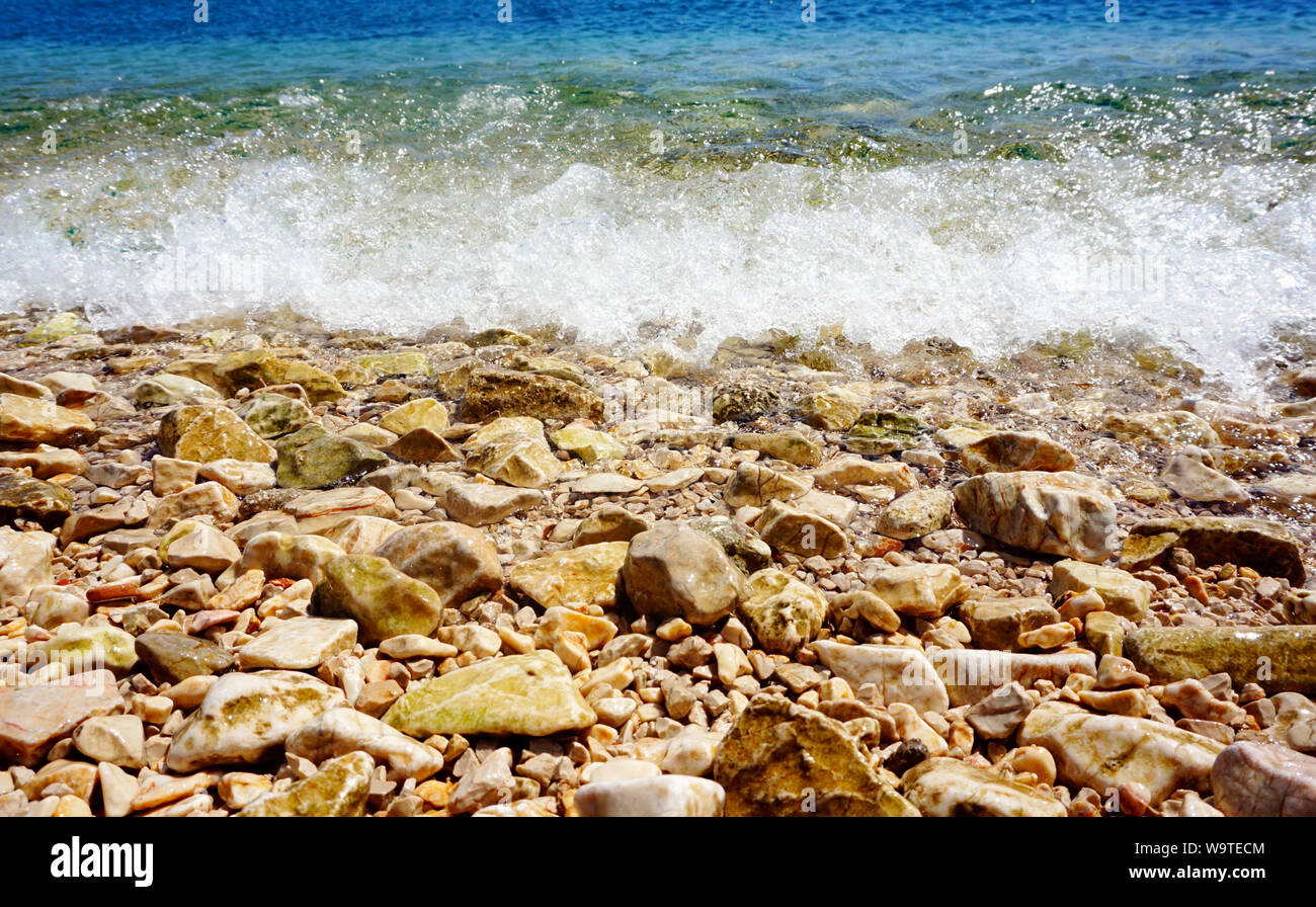 Dynamic tidal white wave splashing on the pebbles sea coast and beach ...