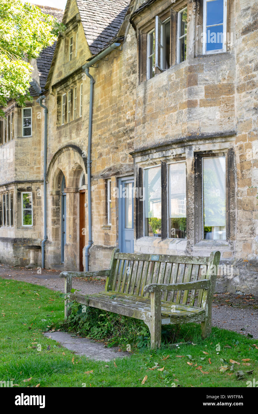 Old wooden bench in front of Cotswold stone houses in sheep street ...