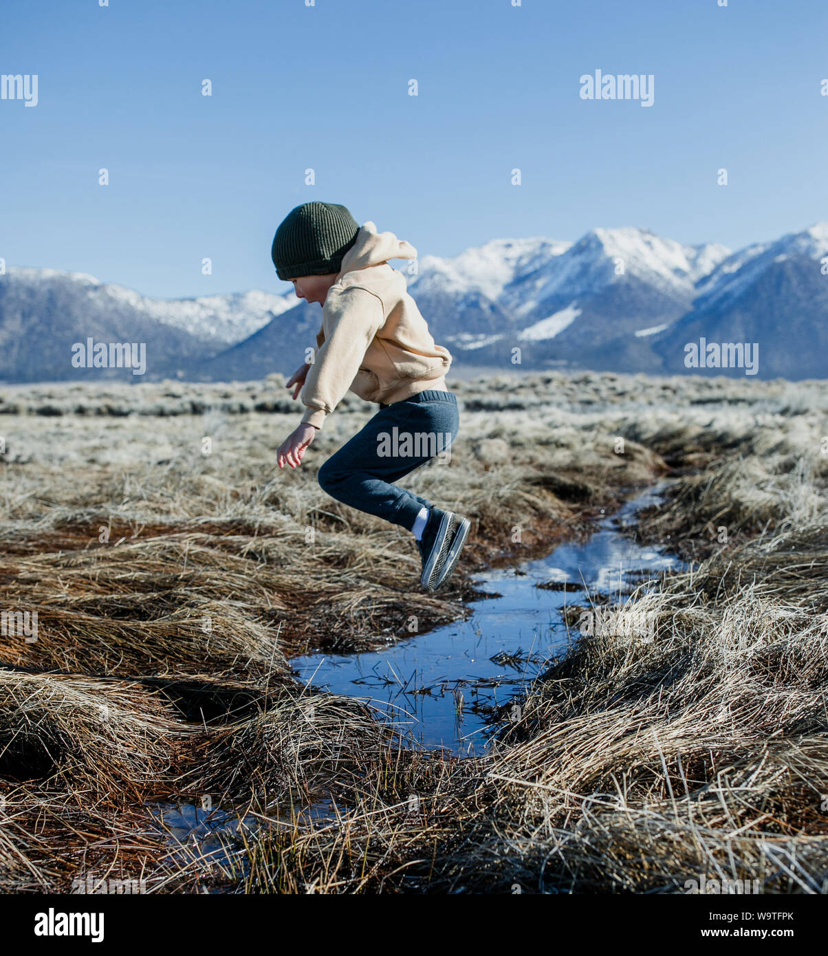 Boy jumping over a stream, Mammoth Lakes, California, United States ...