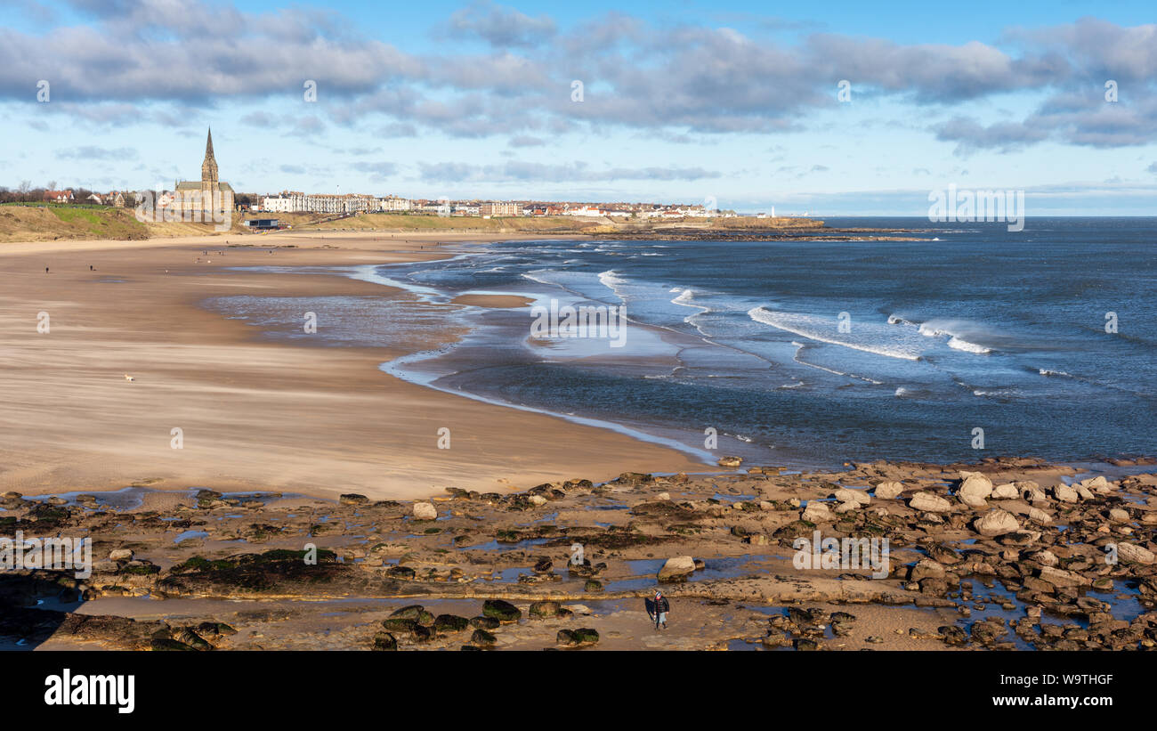 Tynemouth, England, UK - February 4, 2019: People walk dogs while waves ...
