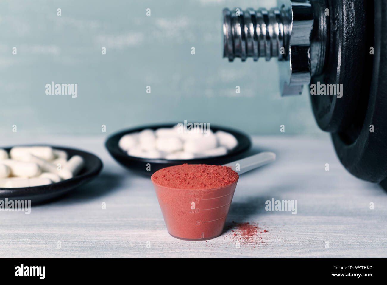 Creatine Powder, Aginine capsules, BCAA (amino acids) and a dumbbell in ...