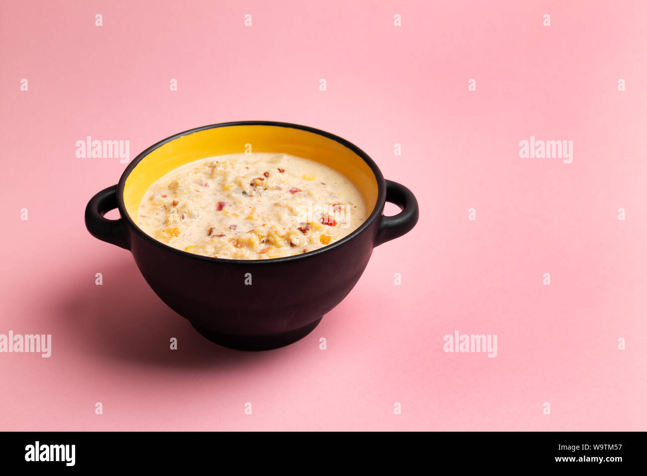 Chowder with Sweet Corn, Shrimp and Bacon in black bowl on pink ...
