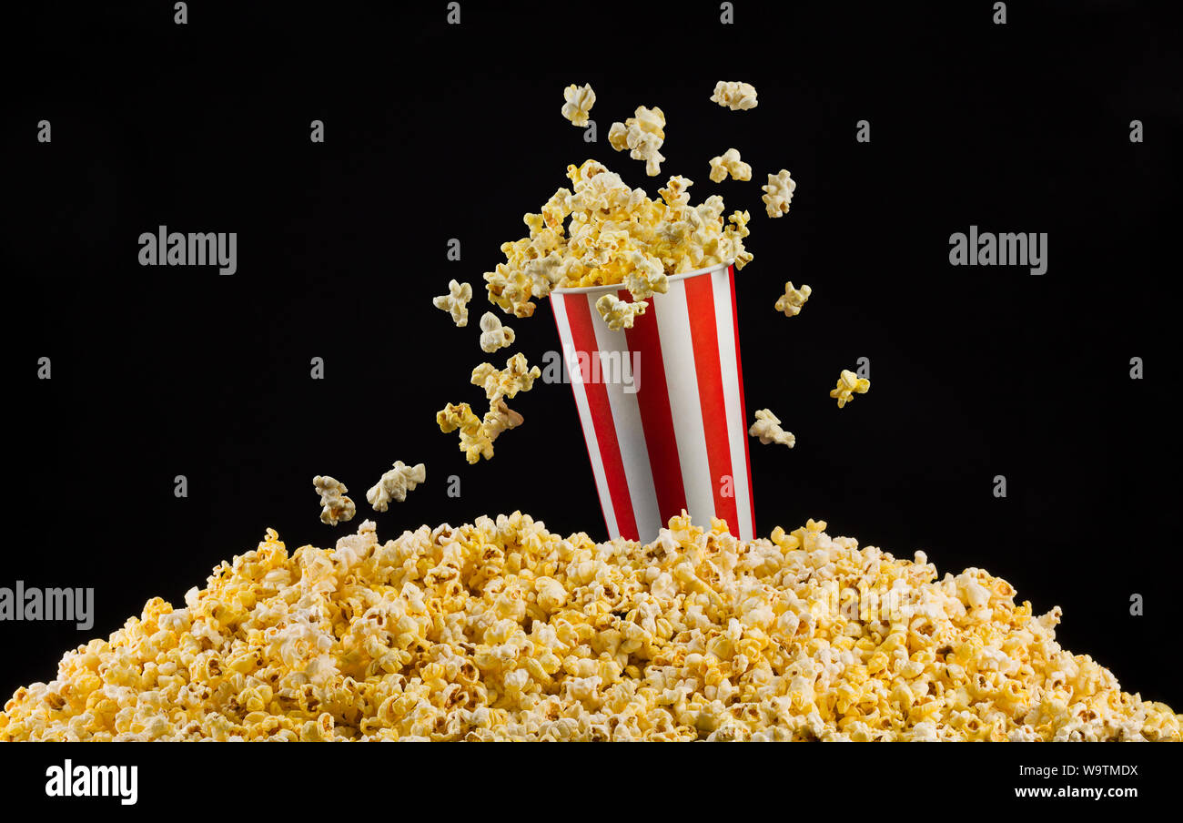 Flying popcorn from striped bucket isolated on black background Stock ...