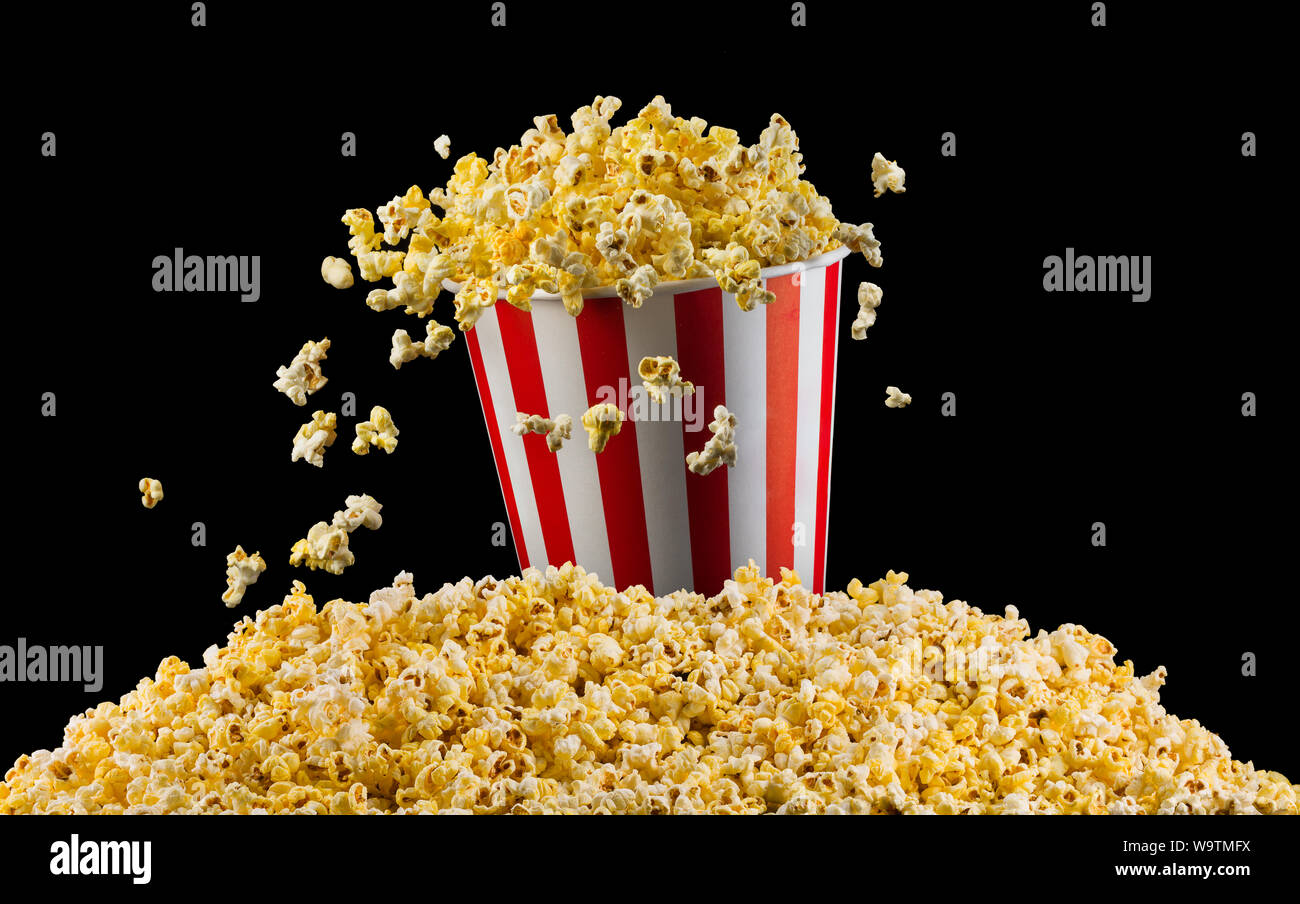 Flying popcorn from striped bucket isolated on black background Stock ...