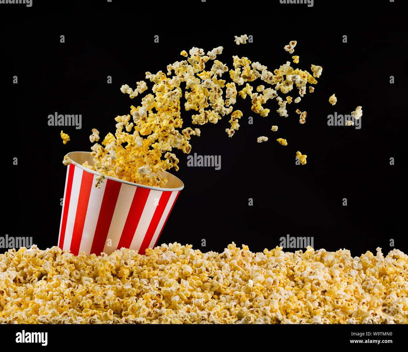 Flying popcorn from striped bucket isolated on black background Stock ...