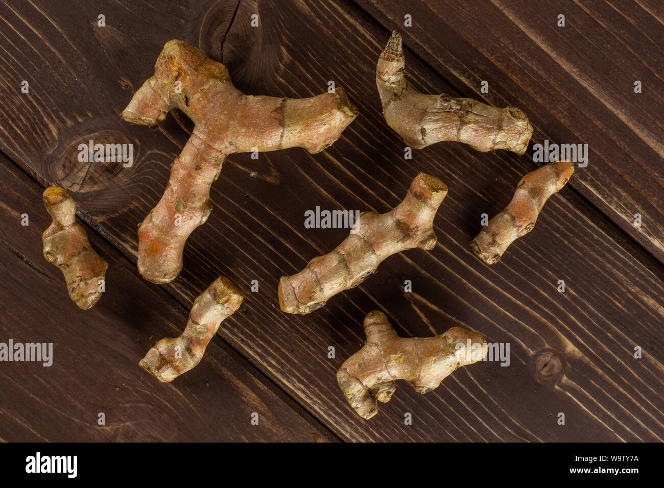 Group of seven whole bright turmeric rhizome like letter flatlay on ...