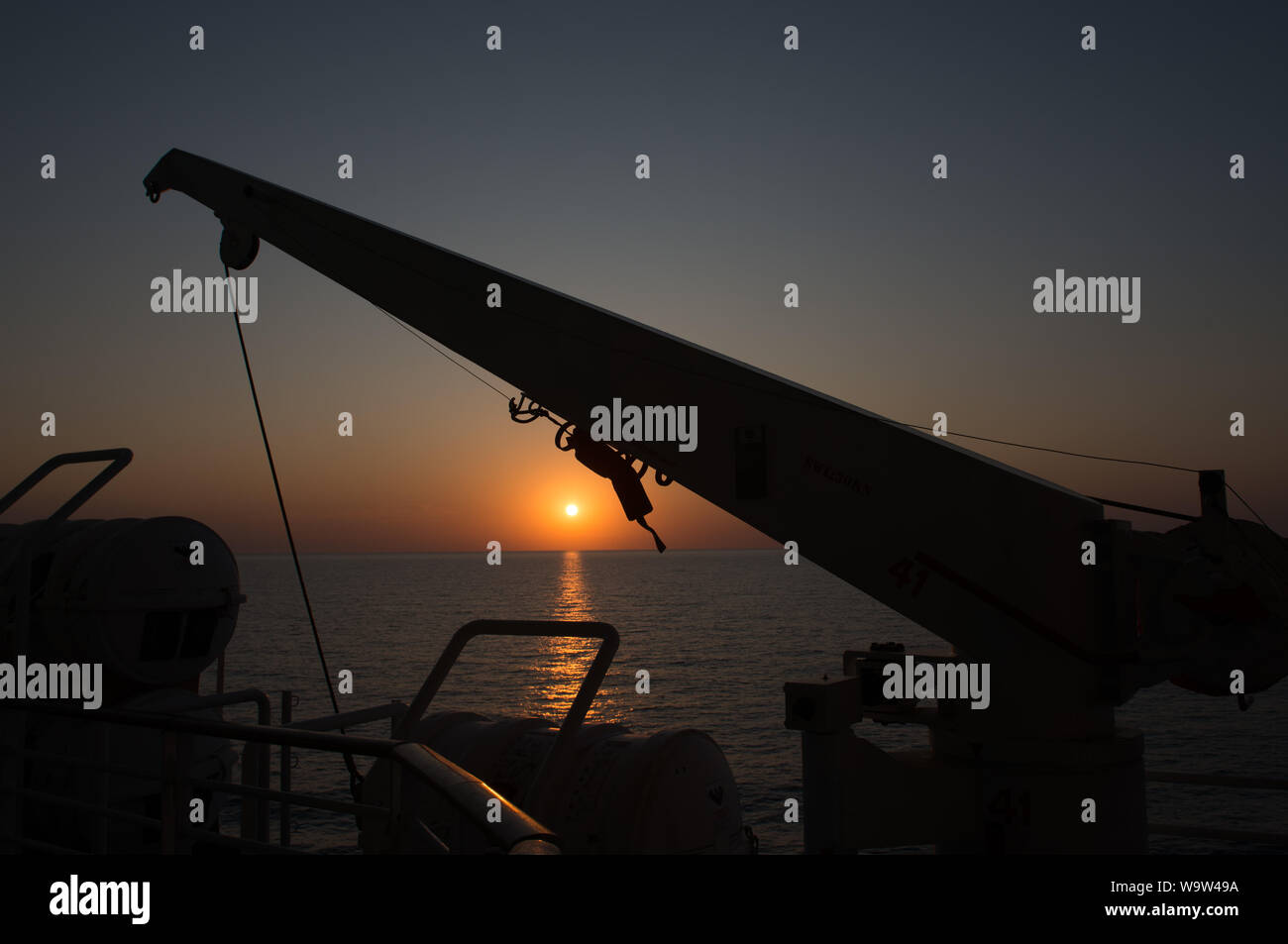 Glowing sky as the sun sets on the sea, onboard nautical vessal with ...