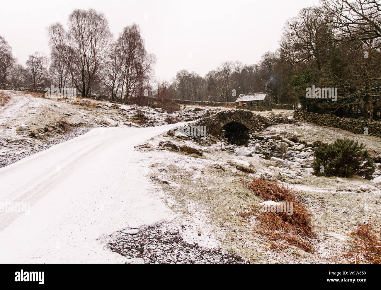 Winter snow lies on the picturesque stone arch bridge and traditional ...