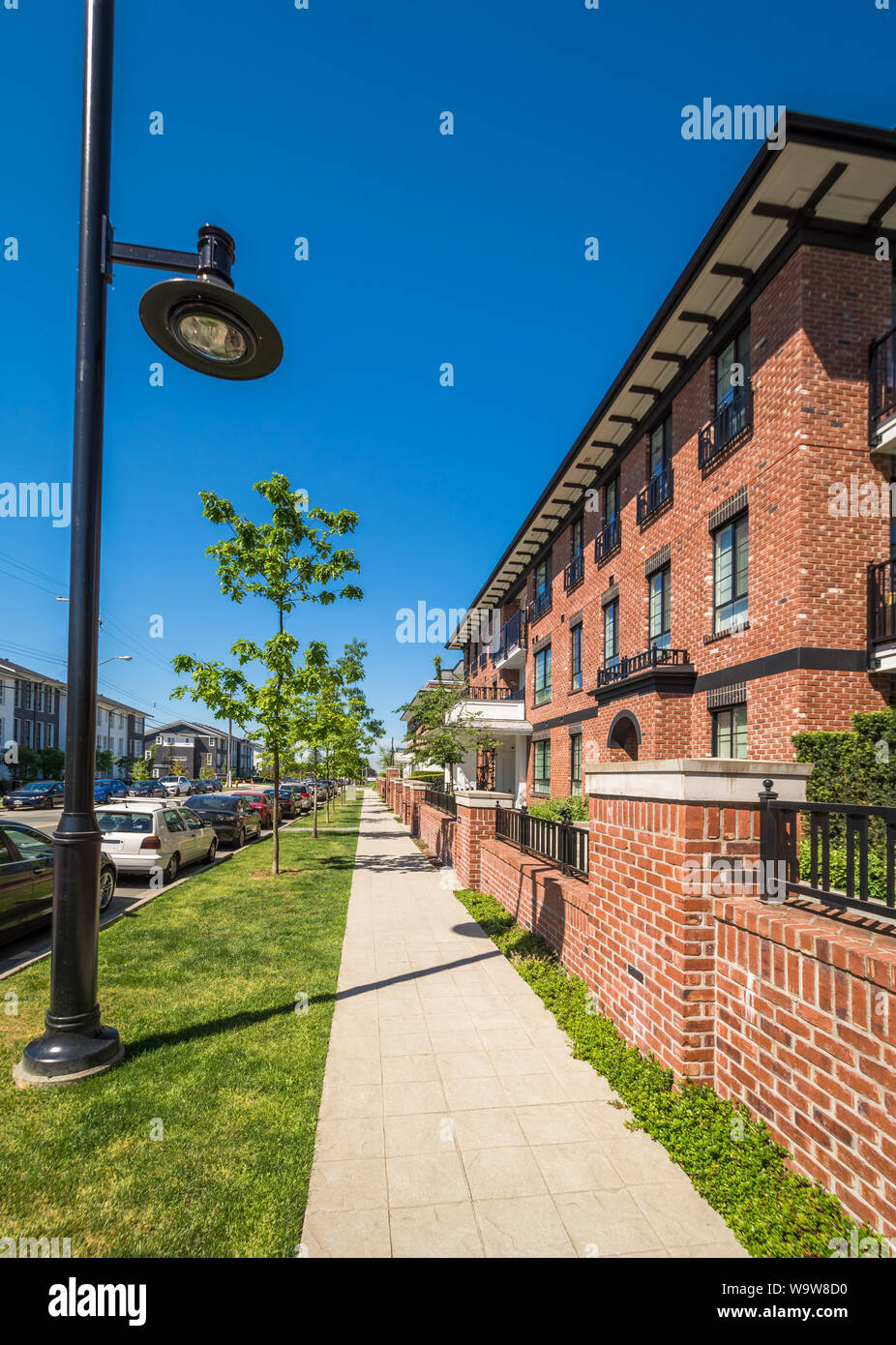 Paved ramp to the entrance of new apartment building on sunny day with ...