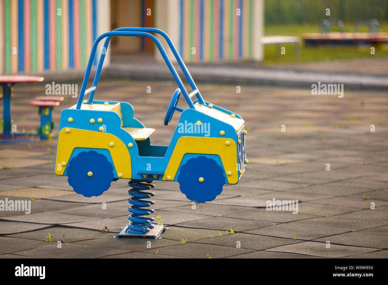 Kindergarten playground with bright toy car on spring. Children ...