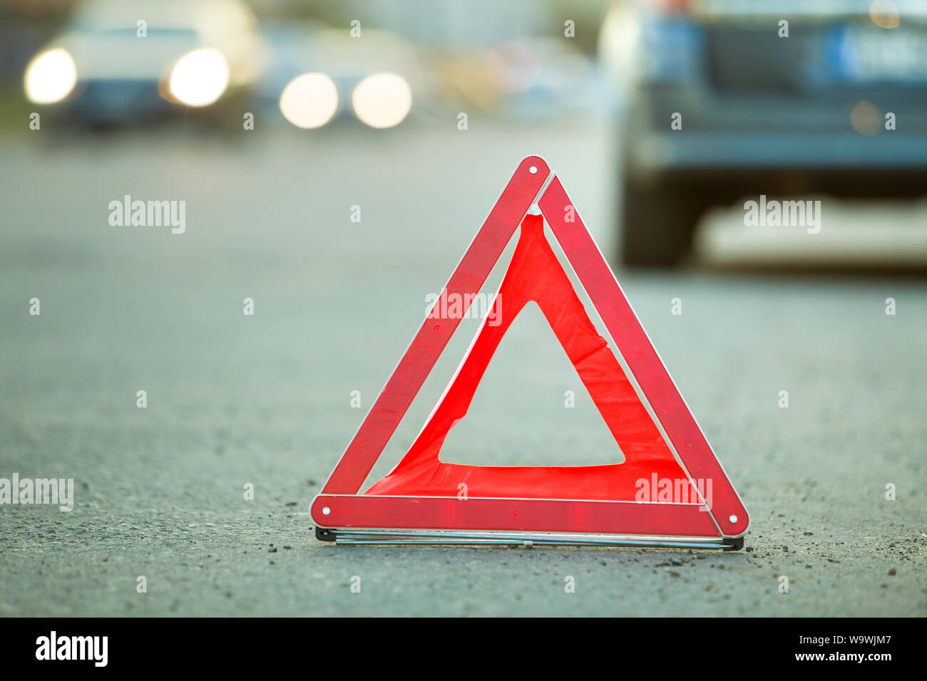 Red emergency triangle stop sign and broken car on a city street Stock ...