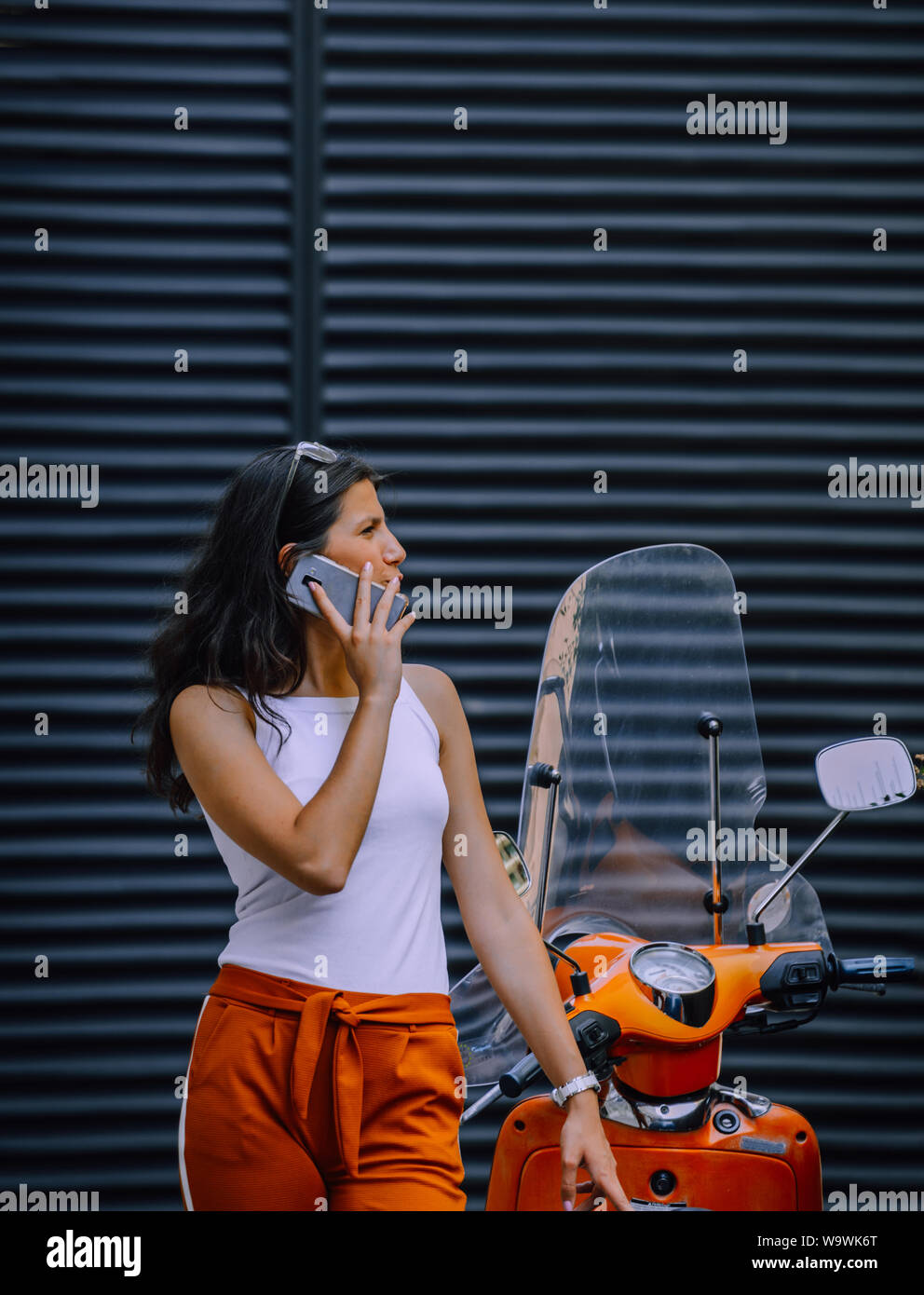 Successful office woman answers the phone call from her client standing ...